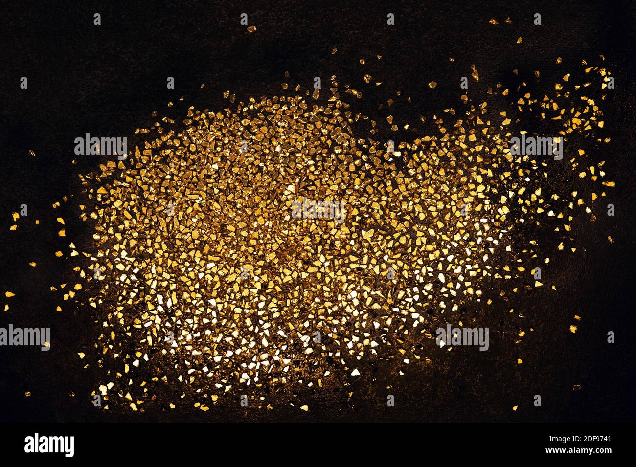 Black background with golden glitter stones. Gold nugget Stock Photo ...