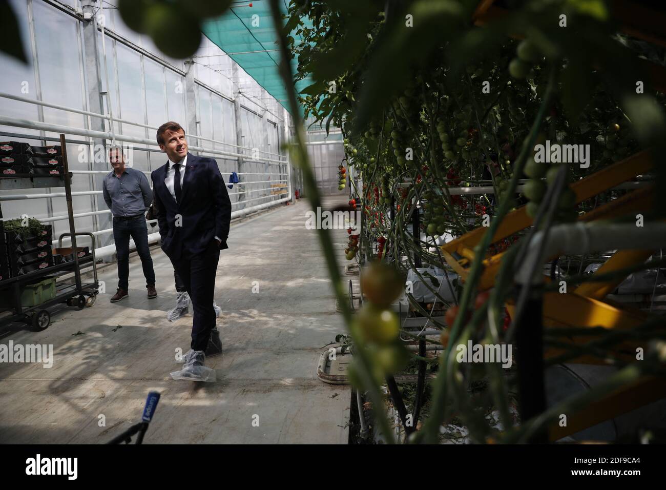 French President Emmanuel Macron talks to farmers in a greenhouse for ...