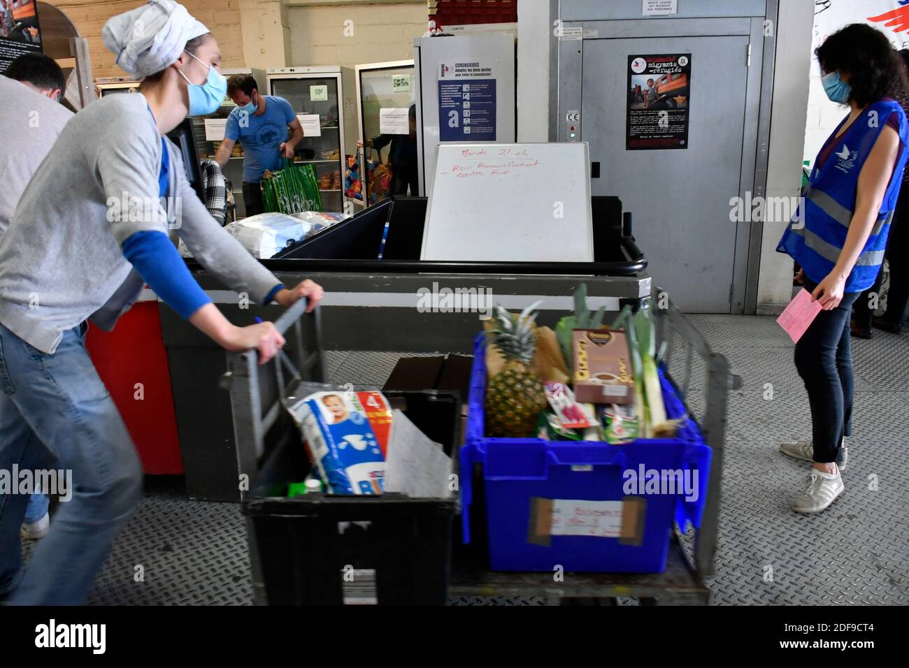 Volunteers organize donated food and put into boxes to be given away at ...