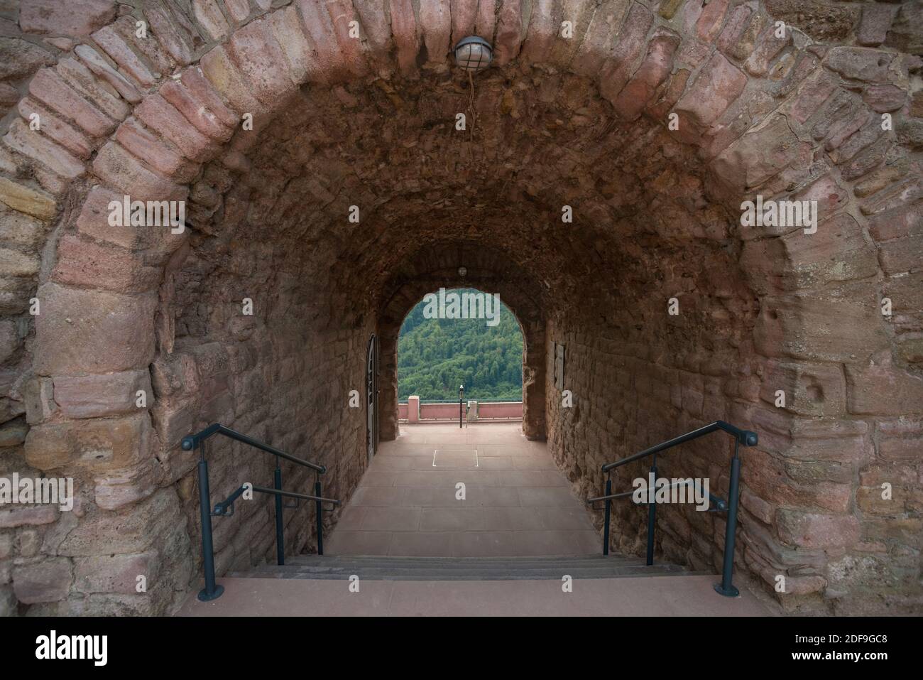 A stone-made ancient tunnel with an arched opening and view of nature ...