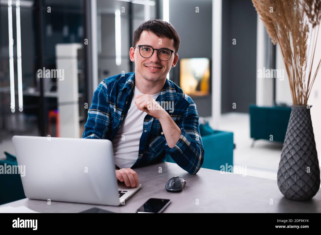 Portrait of handsome young man working remotely at home and smiling ...