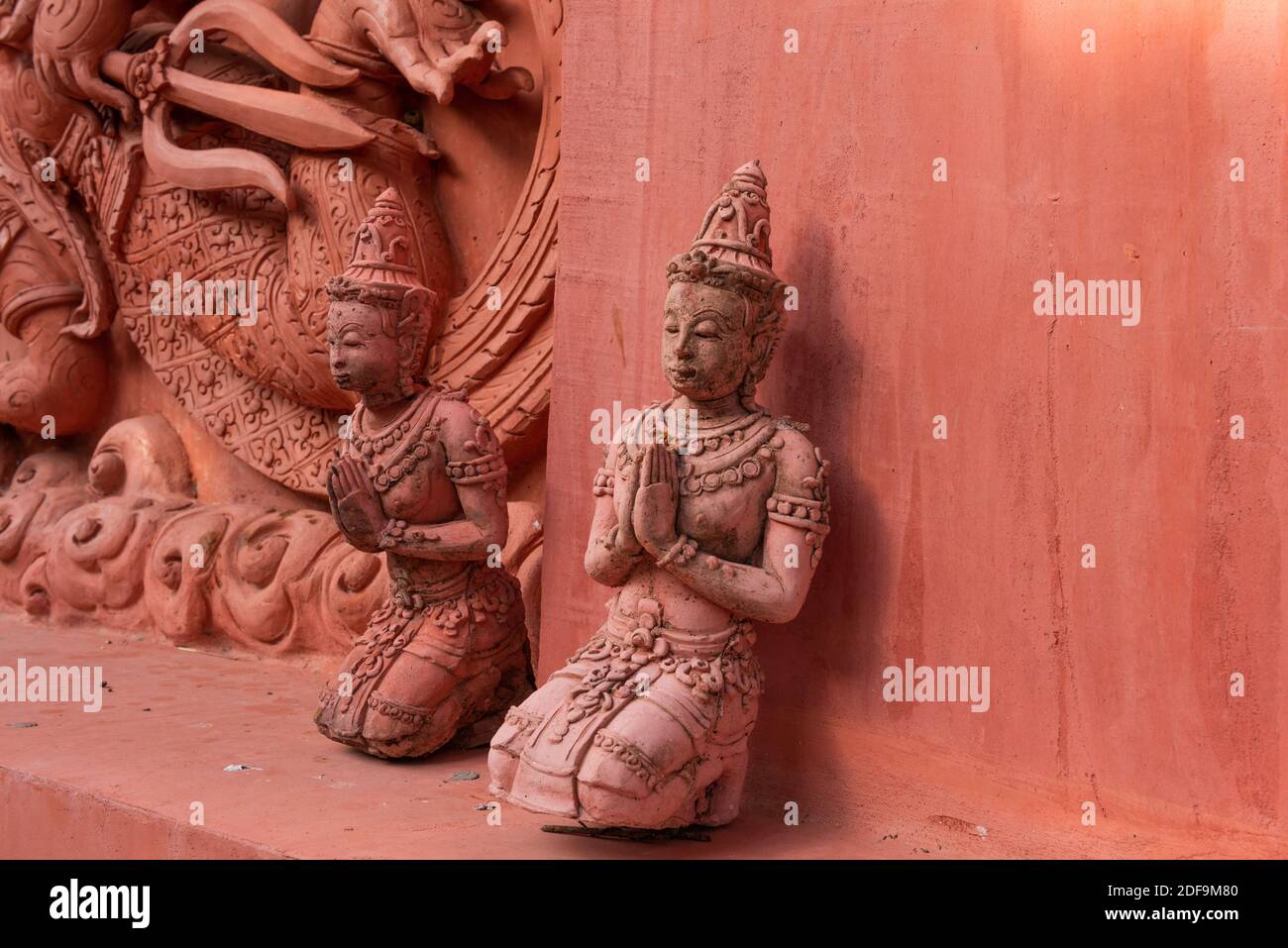 Statues on the outside of the red temple in Thailand, Ko Samui, praying ...
