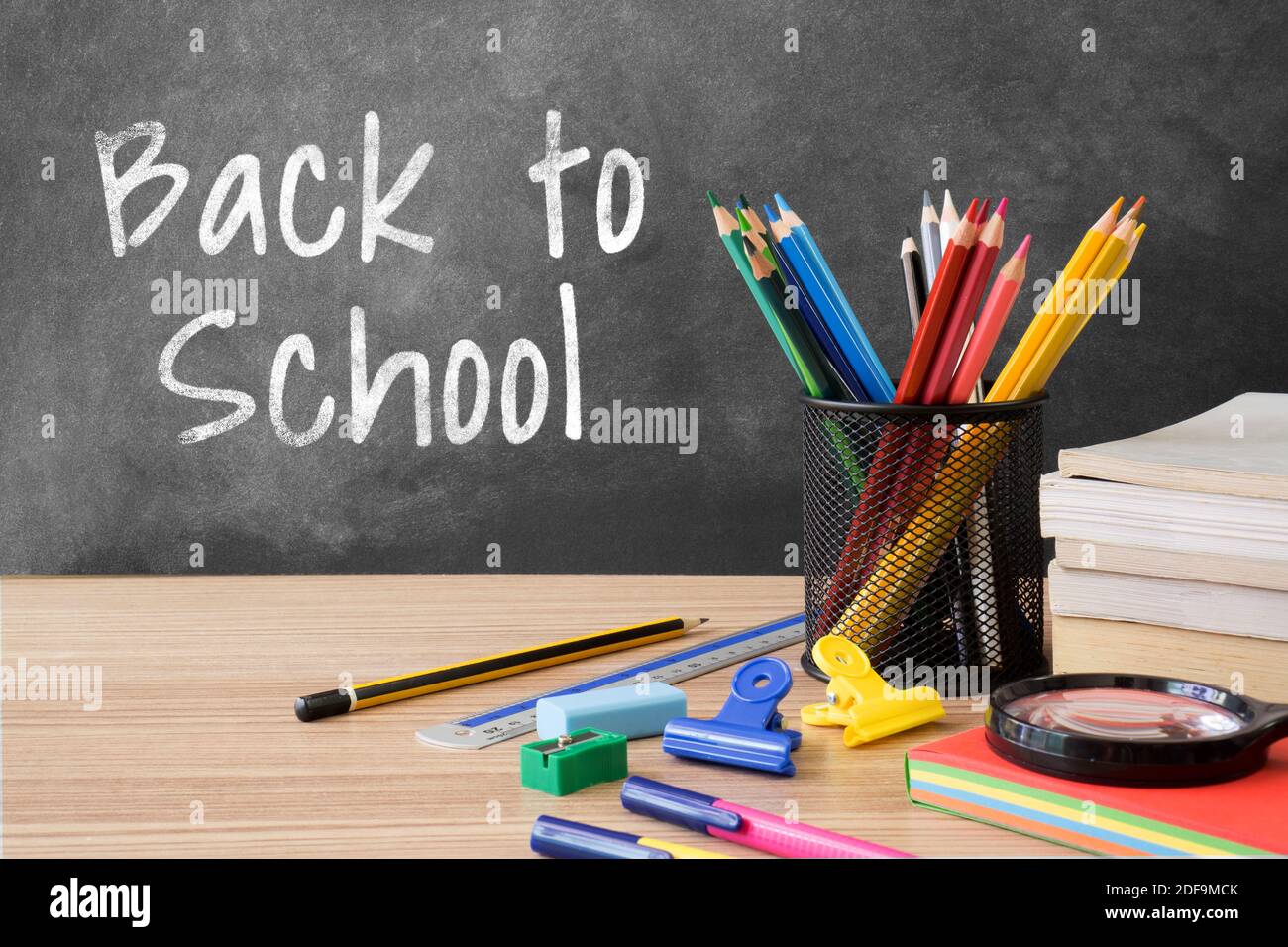 Back to School written on blackboard with multiple stationery items on ...