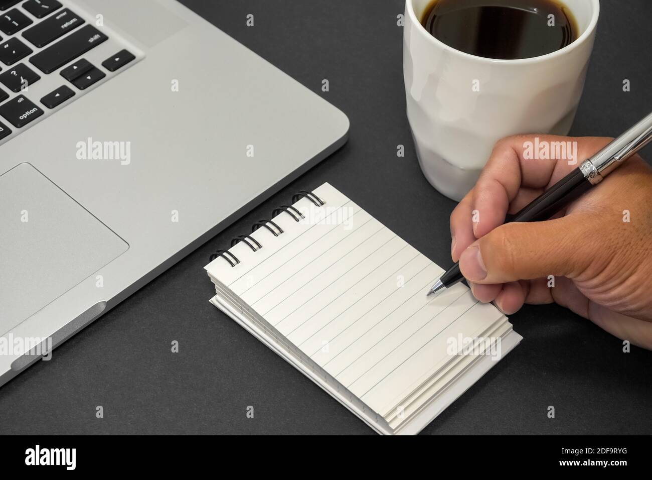 Hand holding a pen and writing on notebook. Text copy space Stock Photo ...