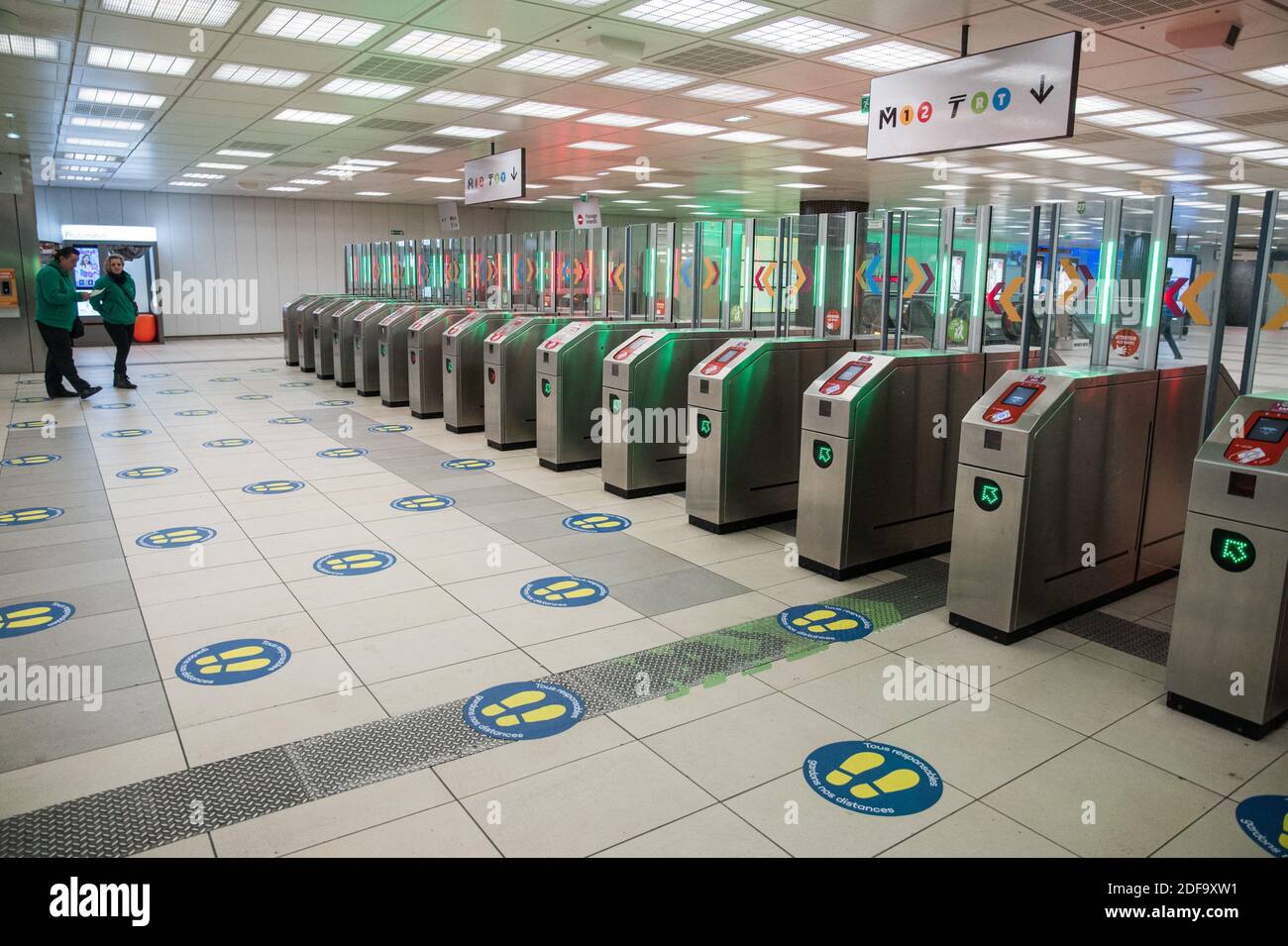 People wait as signs are seen on the floor of Gare Lille Flandres ...