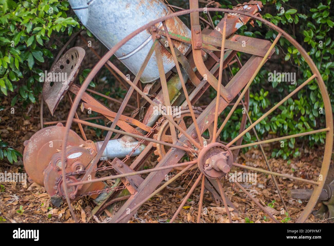 Old rusty farm equipment and green and brown foliage Stock Photo - Alamy