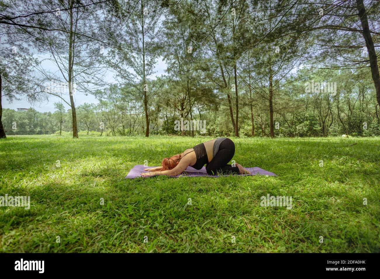 Asian young adult woman doing yoga outdoor under tree shade. Body ...