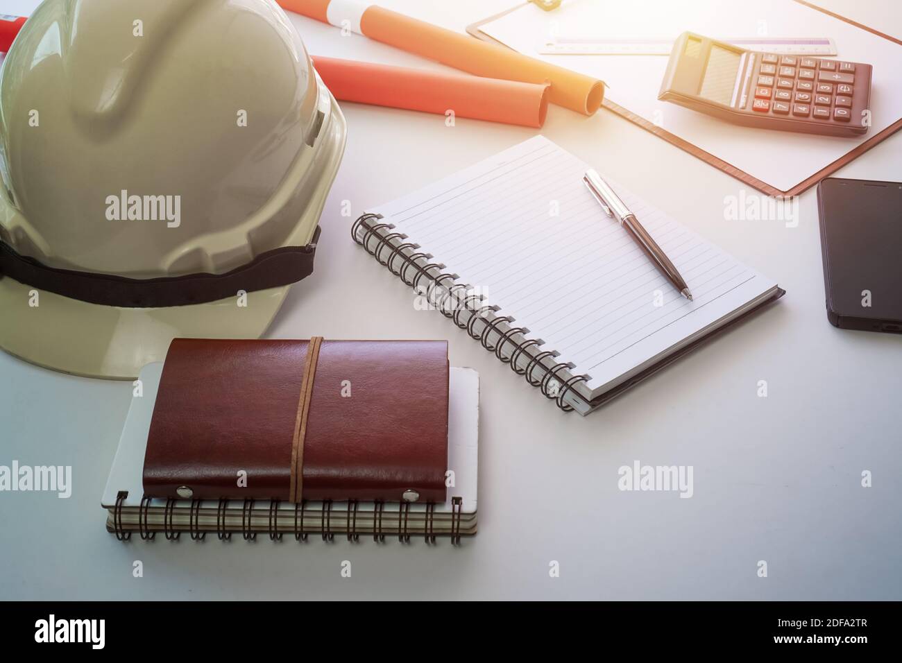 Hard safety hat and notepad on working desk. Project management concept ...