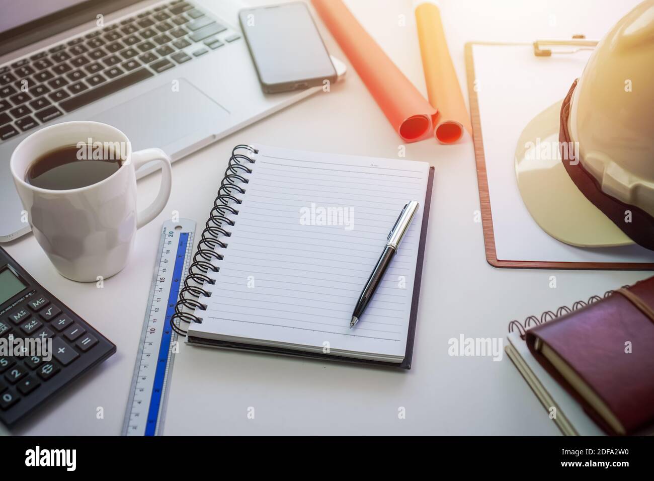 Hard safety hat and notepad on working desk. Project management concept ...