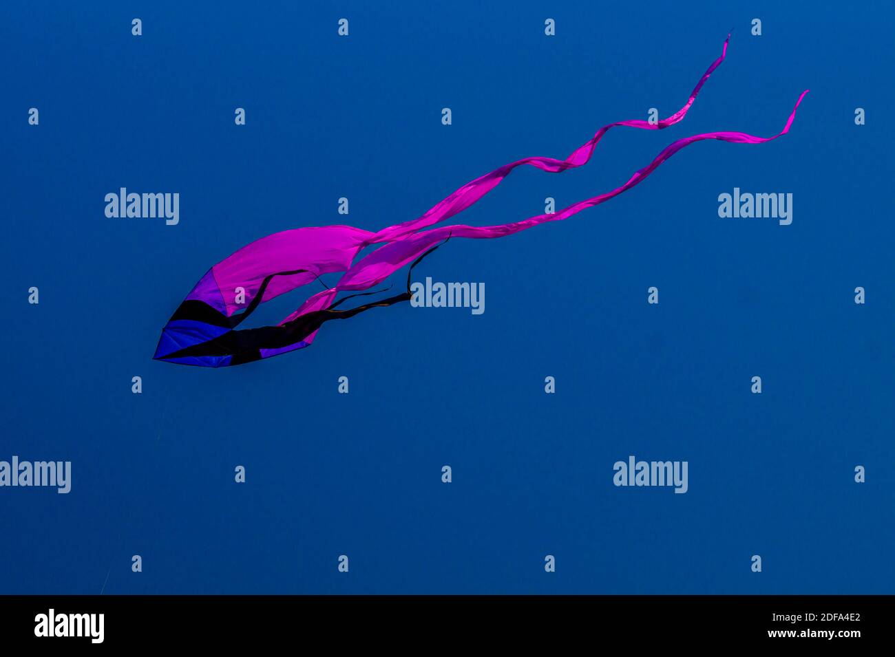 a pink kite flying in the air, blue background Stock Photo - Alamy