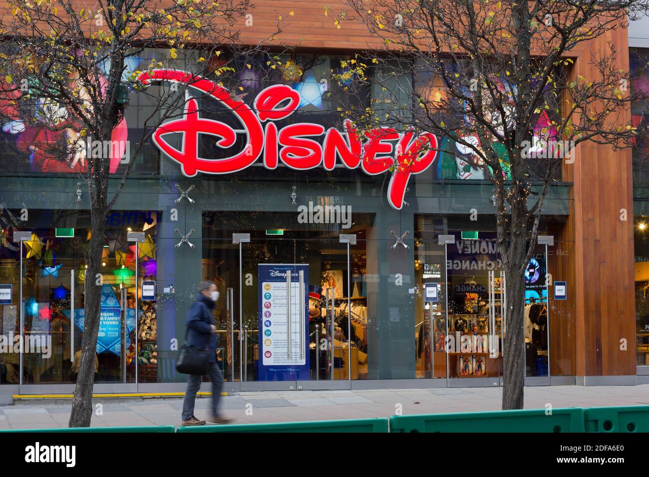 a men in face mask walked past Disney store on Oxford street London ...