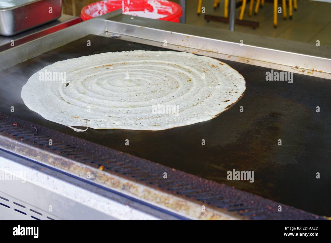 Baking dosa and roti flatbreads on the griddle in Malaysia Stock Photo ...