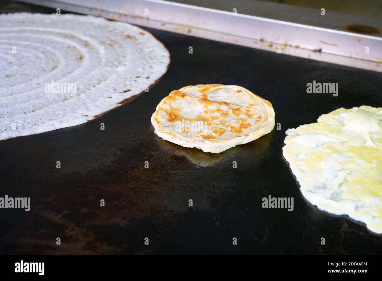 Baking dosa and roti flatbreads on the griddle in Malaysia Stock Photo ...