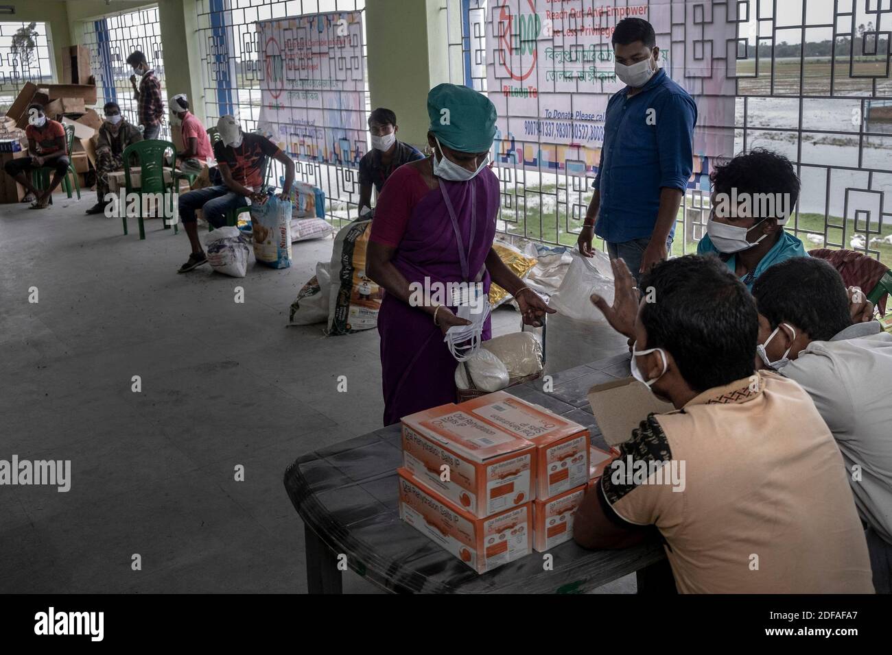 A VILLAGE WOMAN RECIEVING RELIFE METERIALS AT A RELIEF CAMP ORGANISED ...