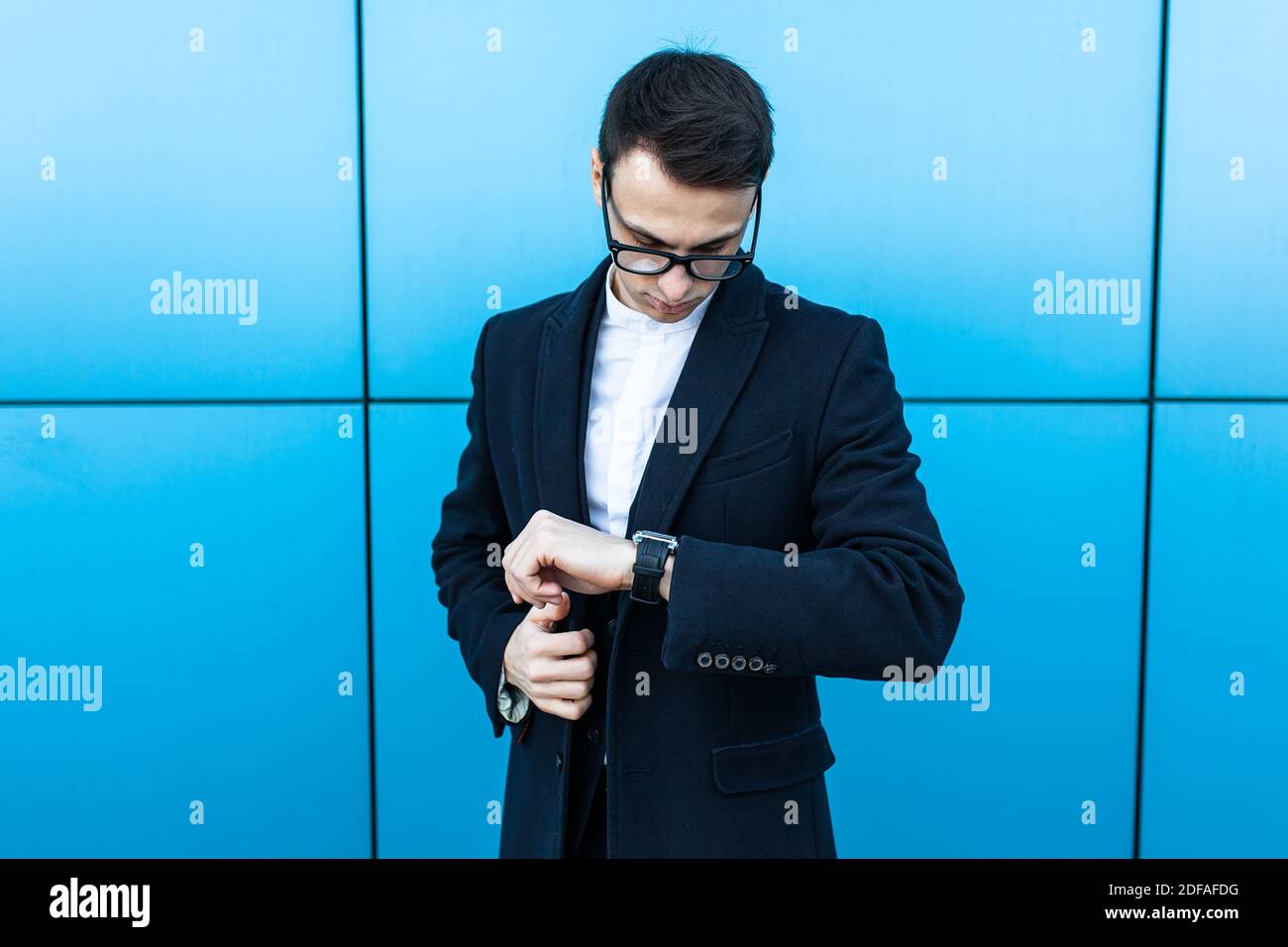 The guy looks at his watch.. Portrait of a cheerful smiling boy on a ...