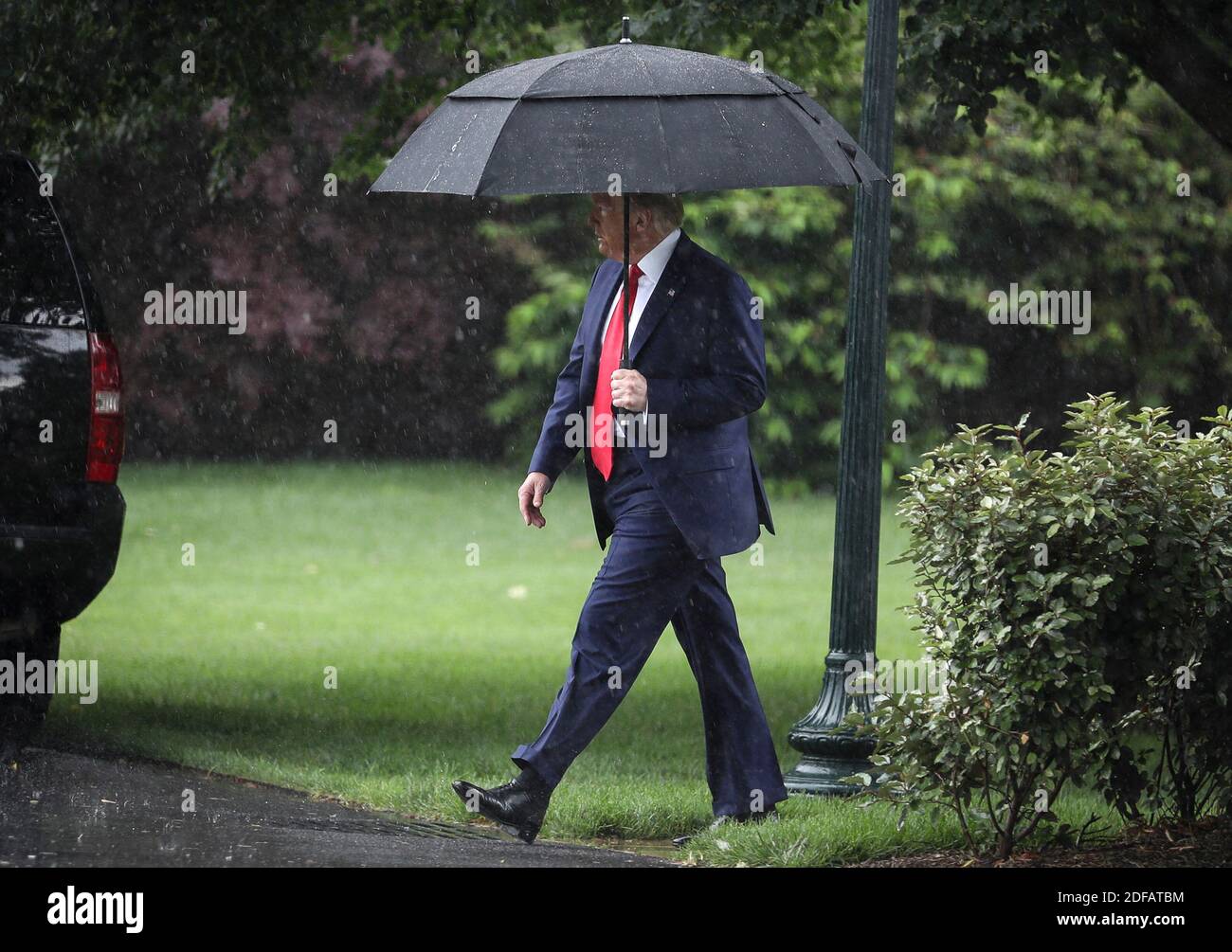 President Donald Trump walks on the South Lawn of the White House in a ...