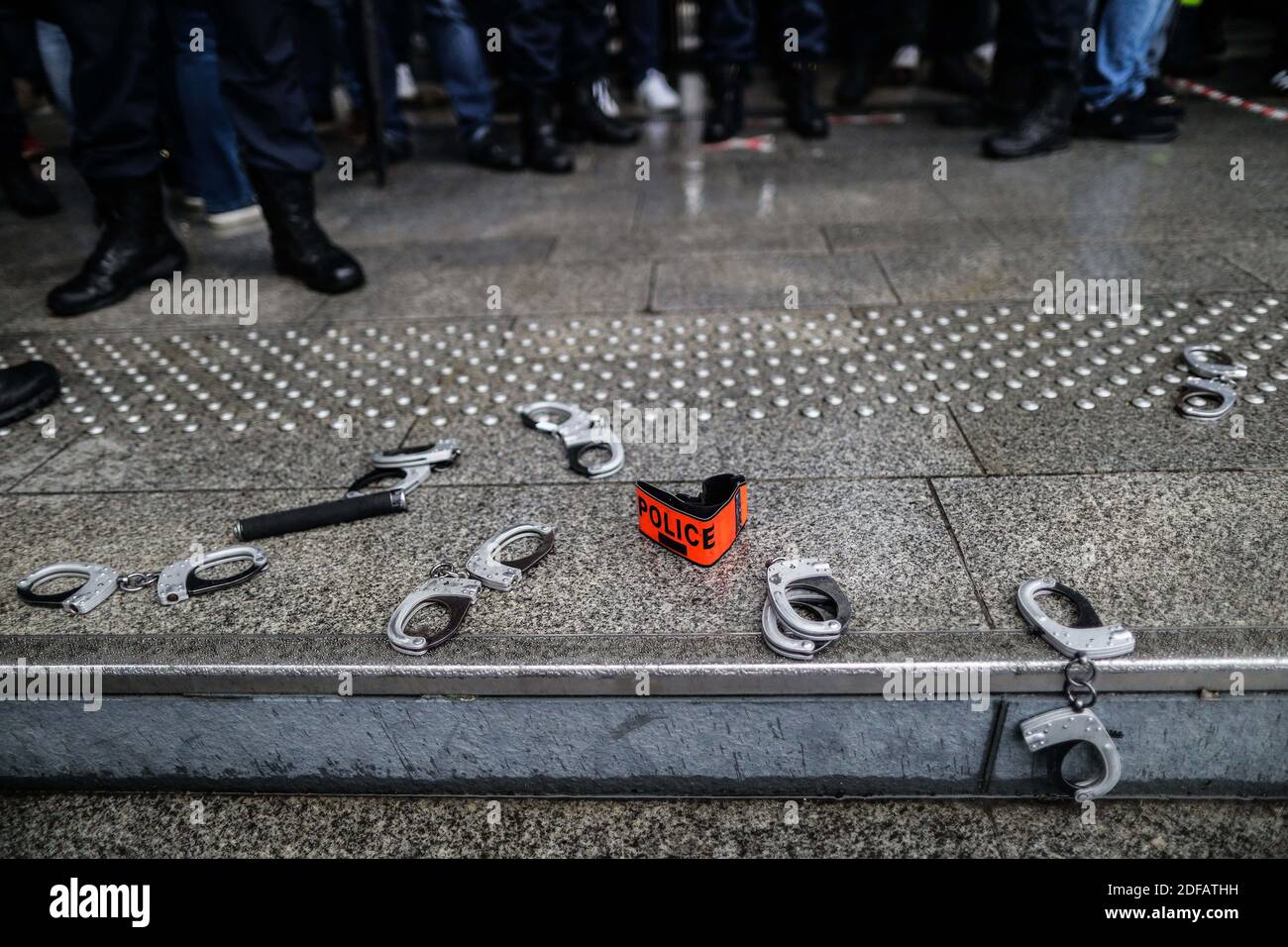 Police demonstrate by putting their handcuffs on the ground at the ...
