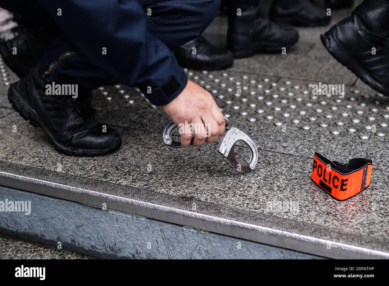 Police demonstrate by putting their handcuffs on the ground at the ...