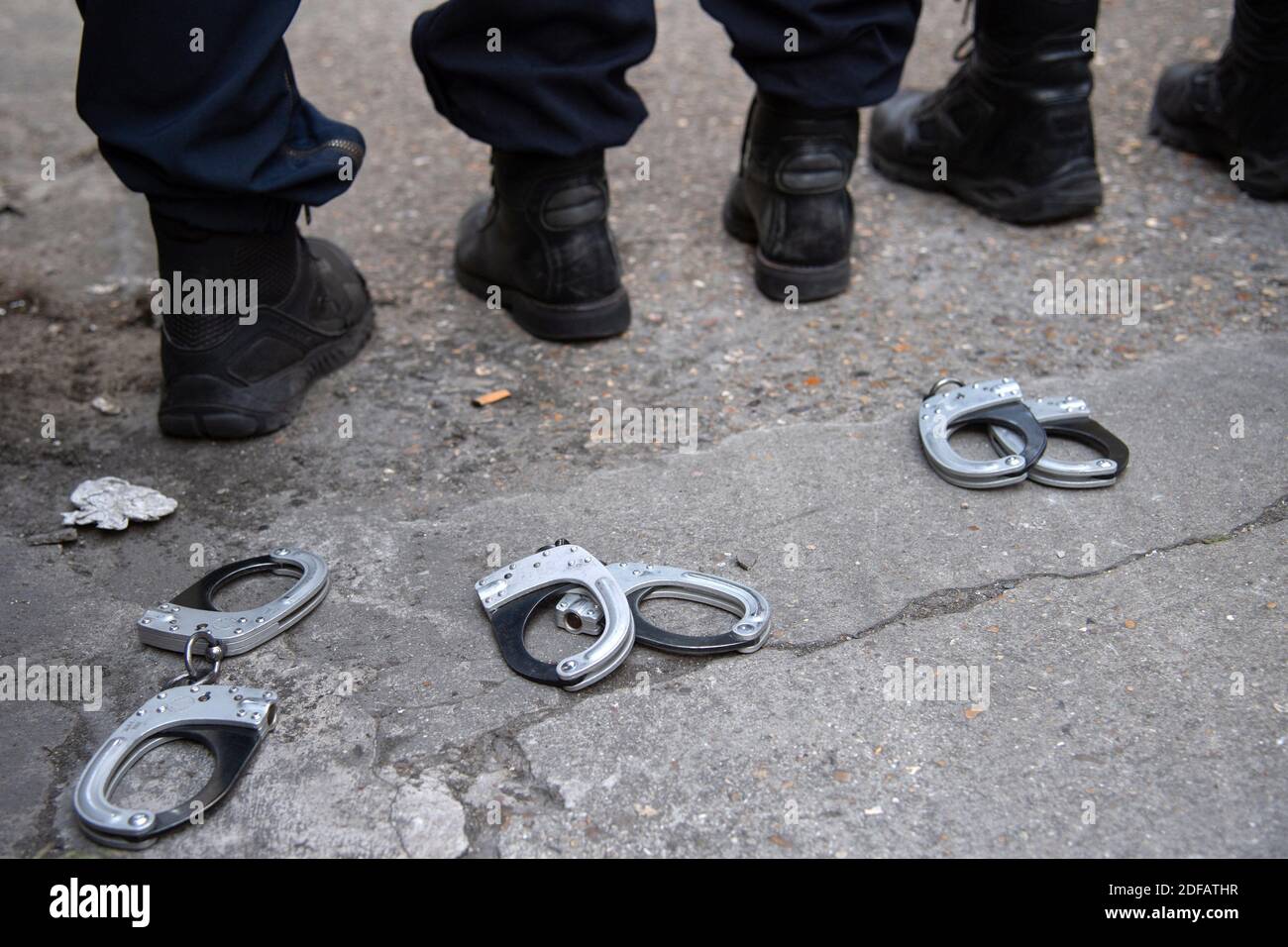 Police officers demonstrate by putting their handcuffs on the ground at ...