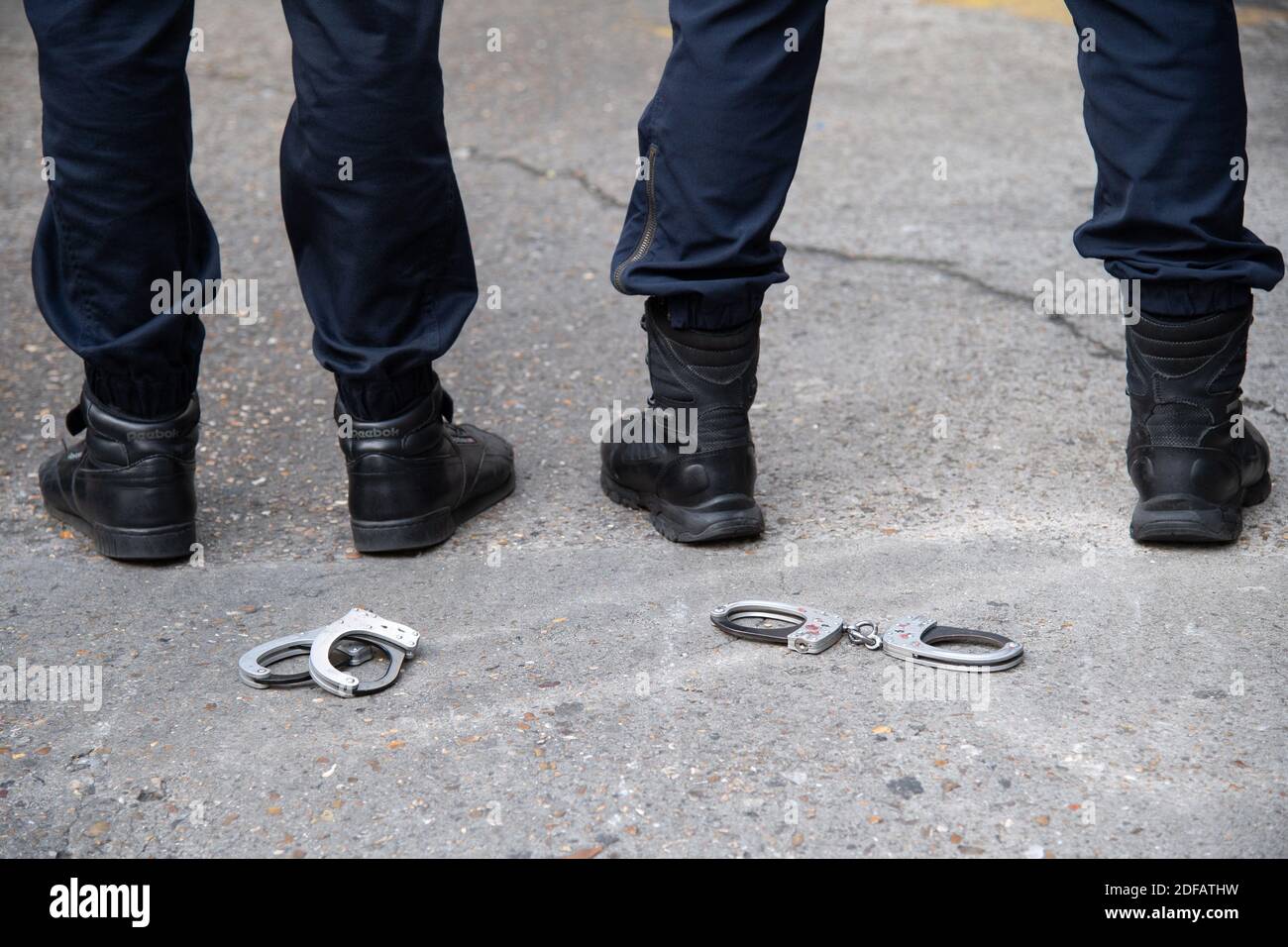 Police officers demonstrate by putting their handcuffs on the ground at ...