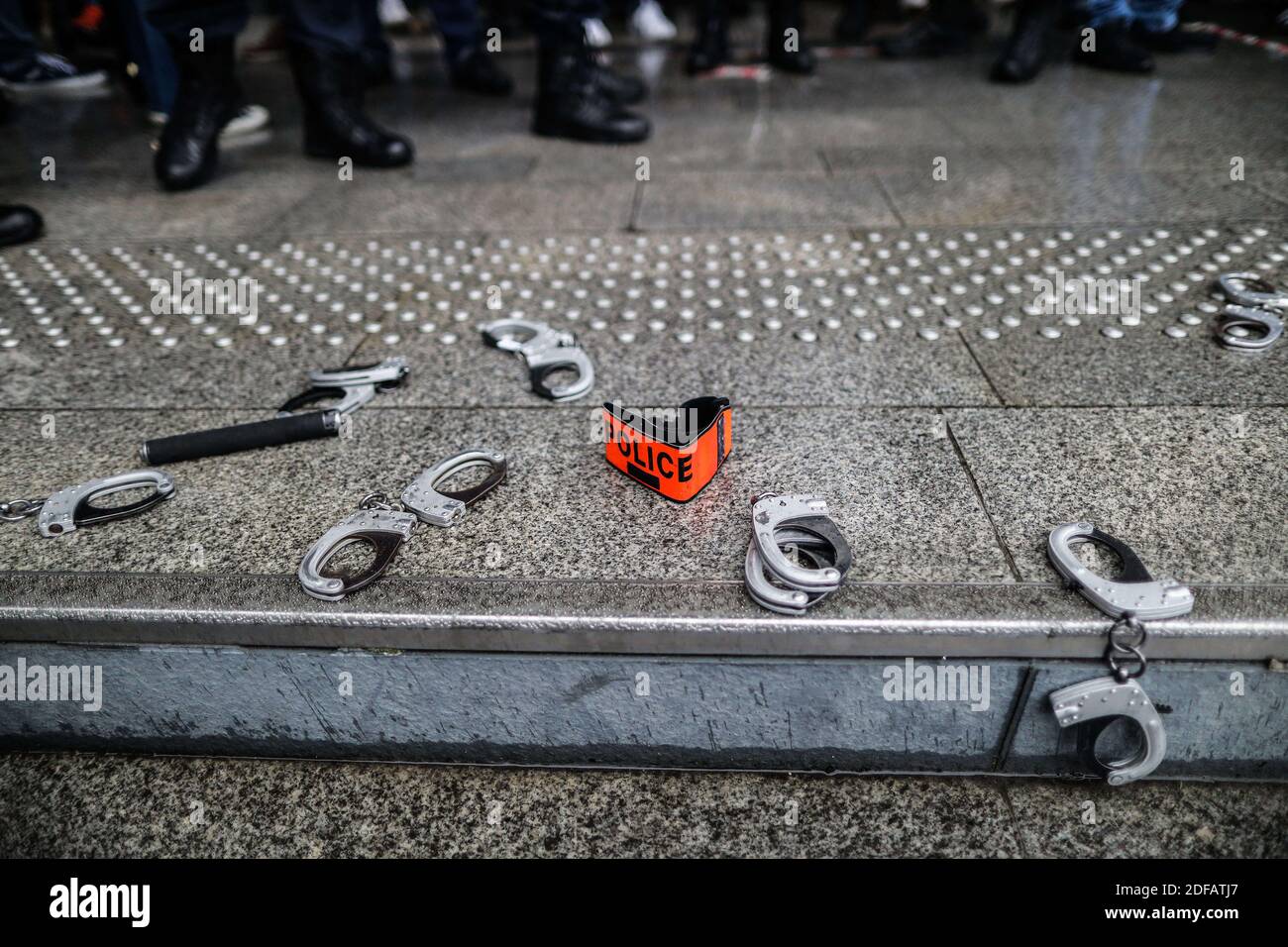 Police demonstrate by putting their handcuffs on the ground at the ...