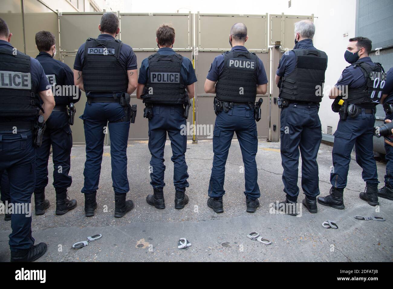 Police officers demonstrate by putting their handcuffs on the ground at ...