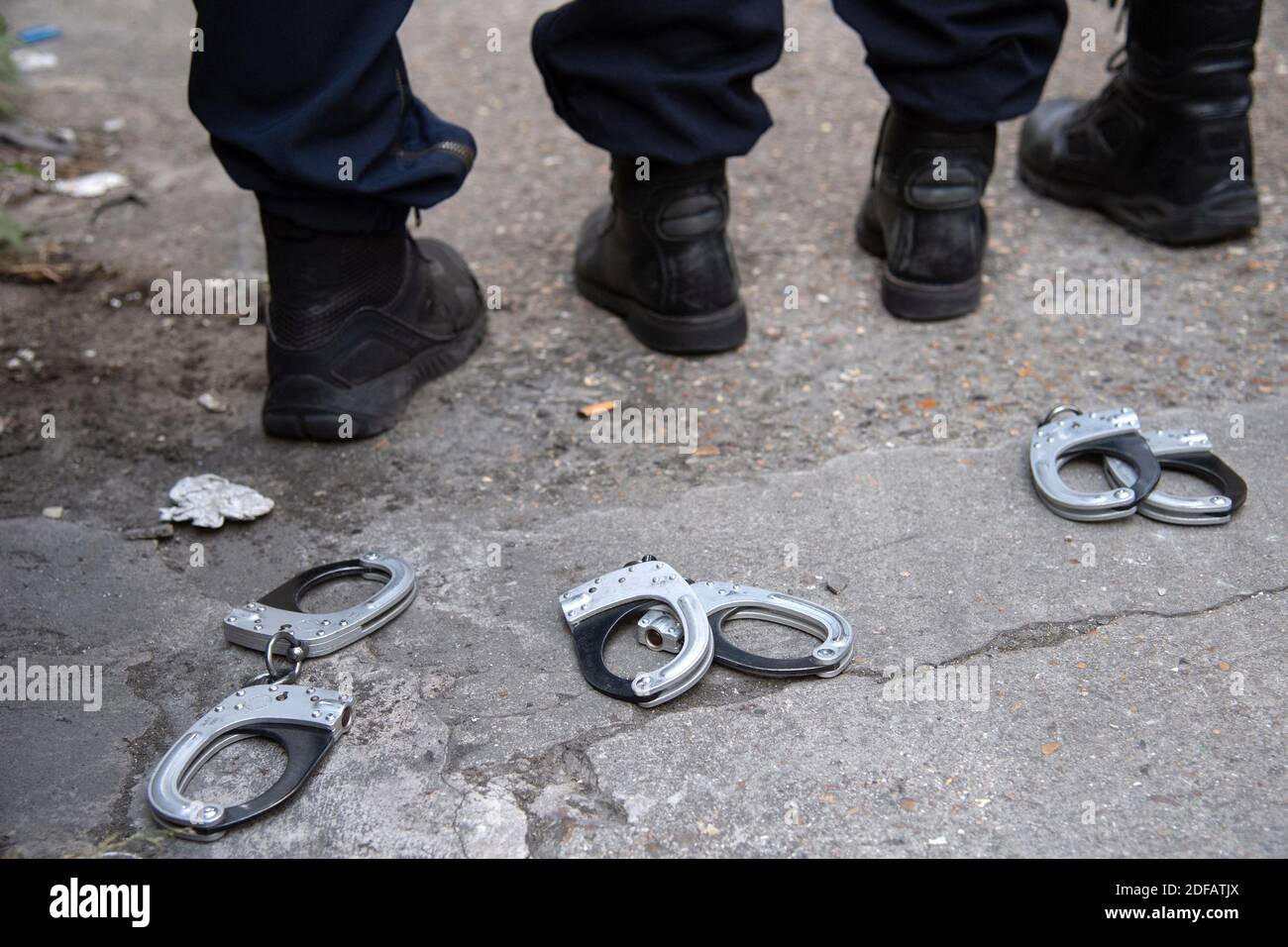 Police officers demonstrate by putting their handcuffs on the ground at ...
