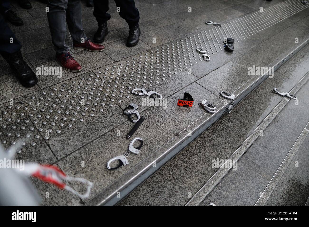 Police demonstrate by putting their handcuffs on the ground at the ...