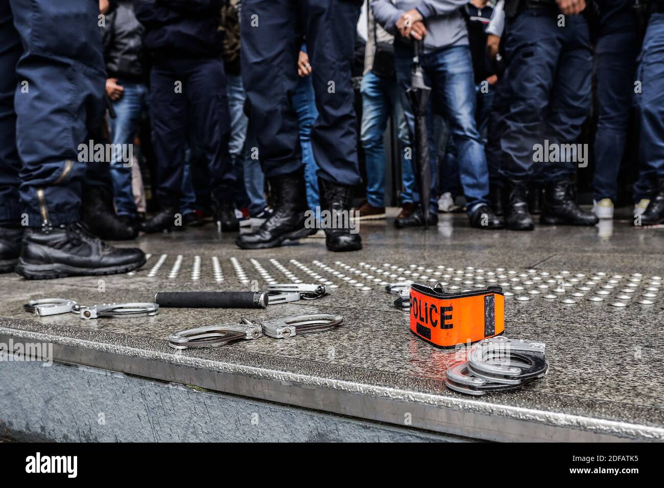 Police demonstrate by putting their handcuffs on the ground at the ...