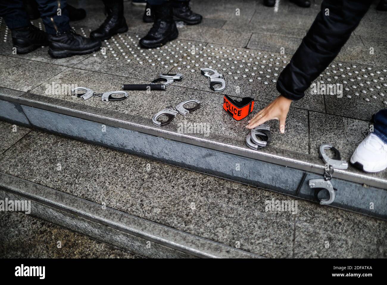 Police demonstrate by putting their handcuffs on the ground at the ...