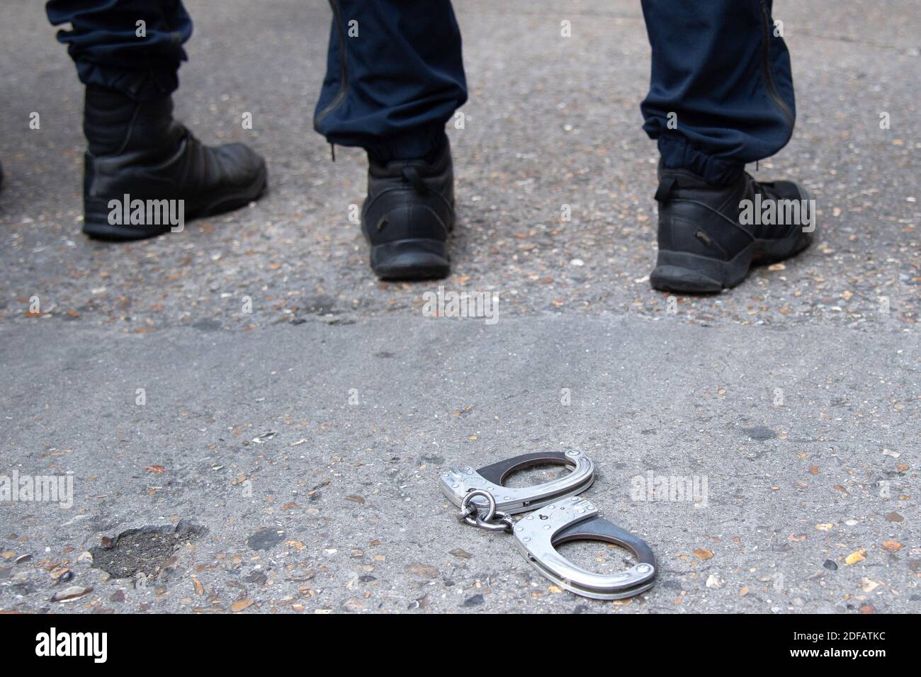 Police officers demonstrate by putting their handcuffs on the ground at ...