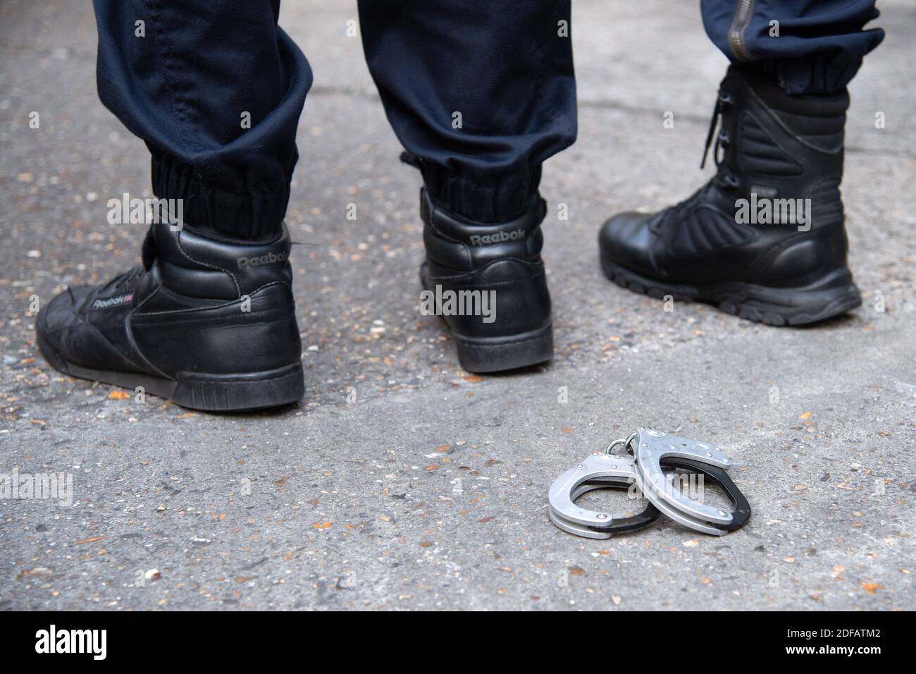 Police officers demonstrate by putting their handcuffs on the ground at ...