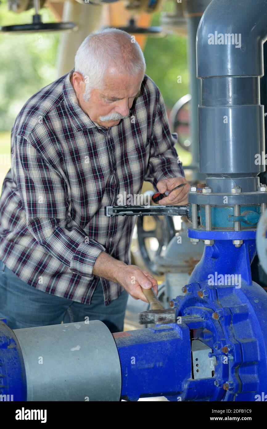 manual worker turning cut-off valve at plant Stock Photo - Alamy