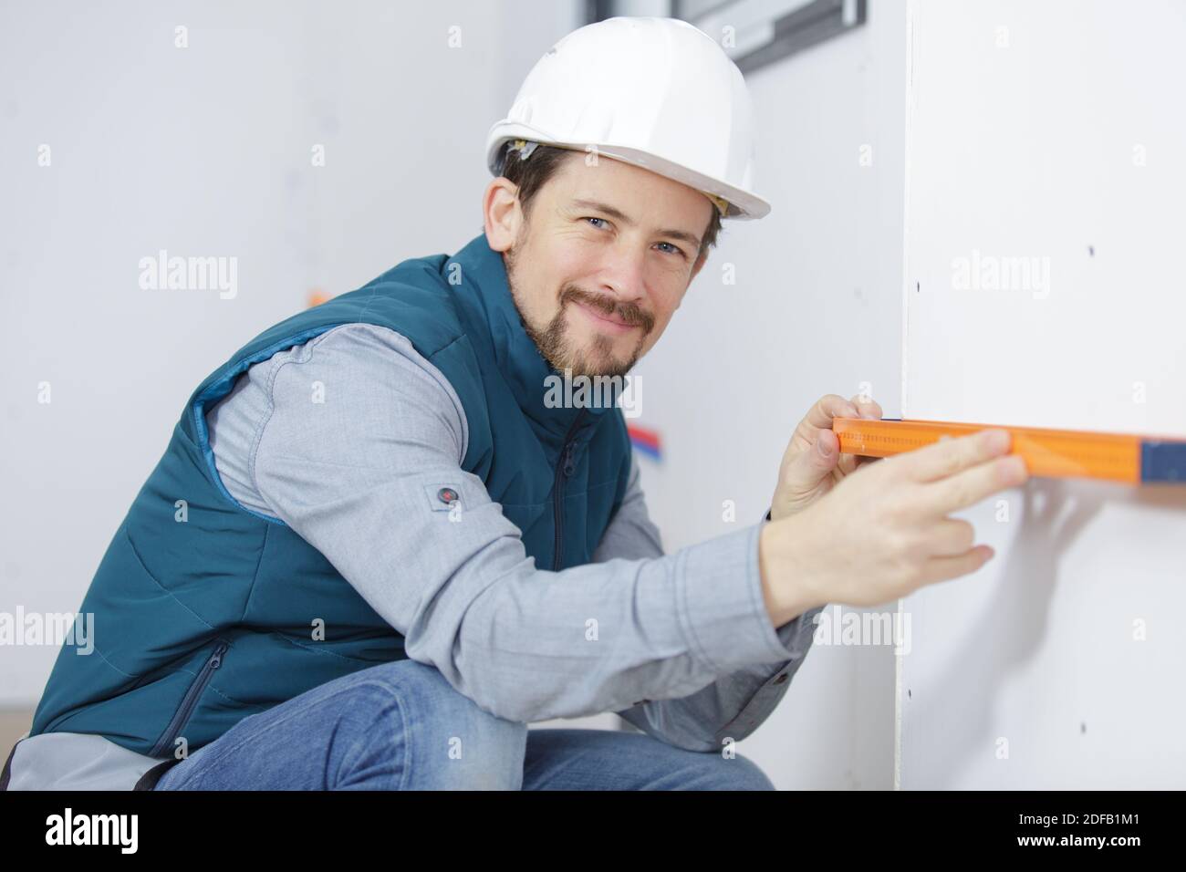 construction worker using spirit level in a new house Stock Photo - Alamy