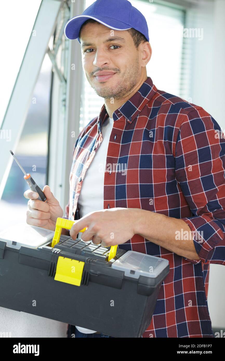 adult male repairman taking screwdriver from toolbox Stock Photo - Alamy