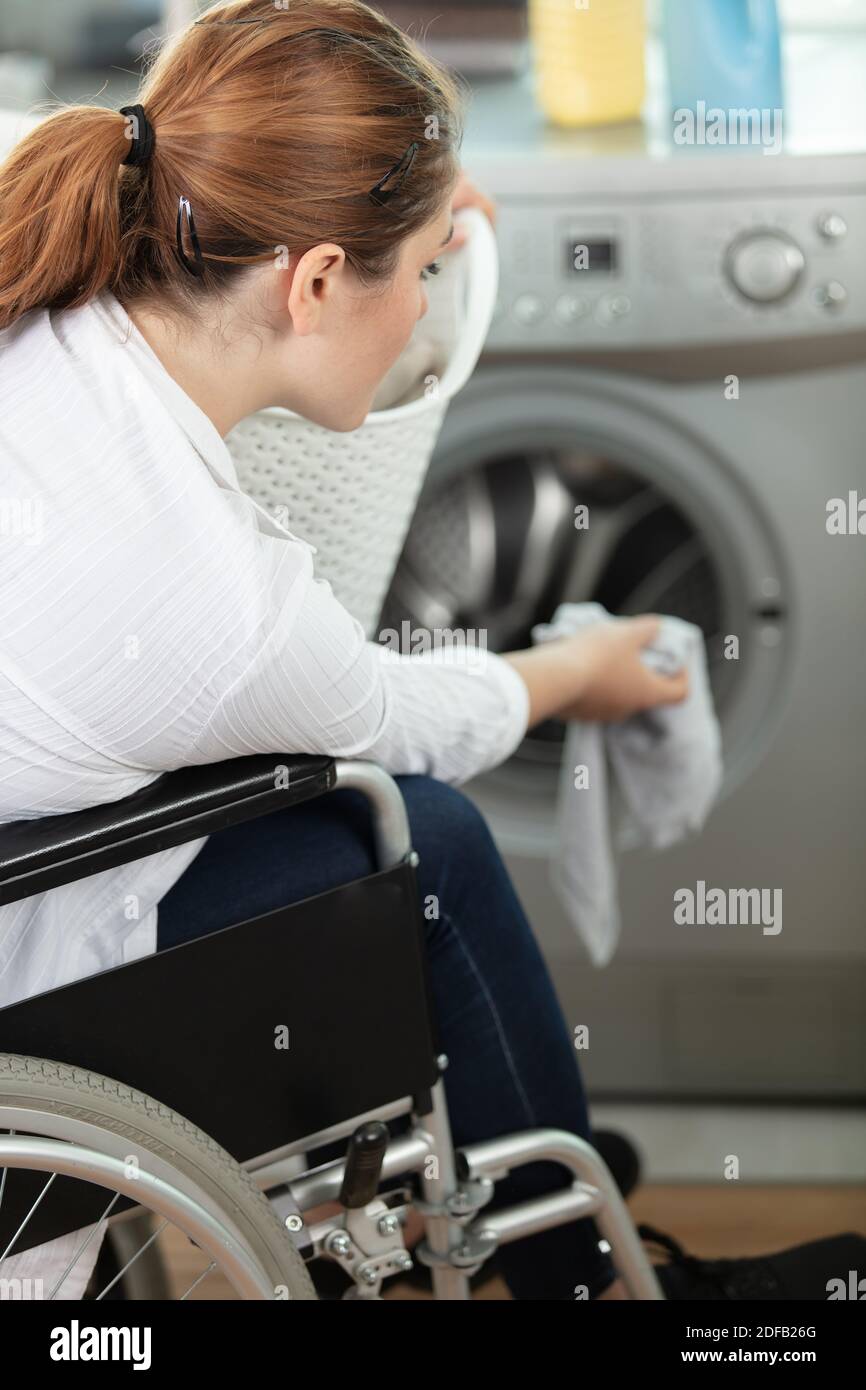 woman in a wheelchair doing the laundry Stock Photo - Alamy