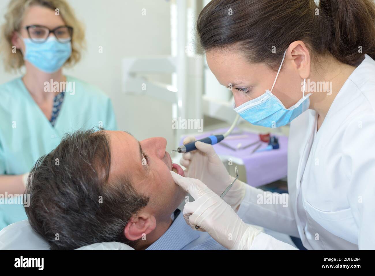 dentist examining a male patient with tools in clinic Stock Photo - Alamy dentist examining a male patient with tools in clinic Stock Photo - Alamy