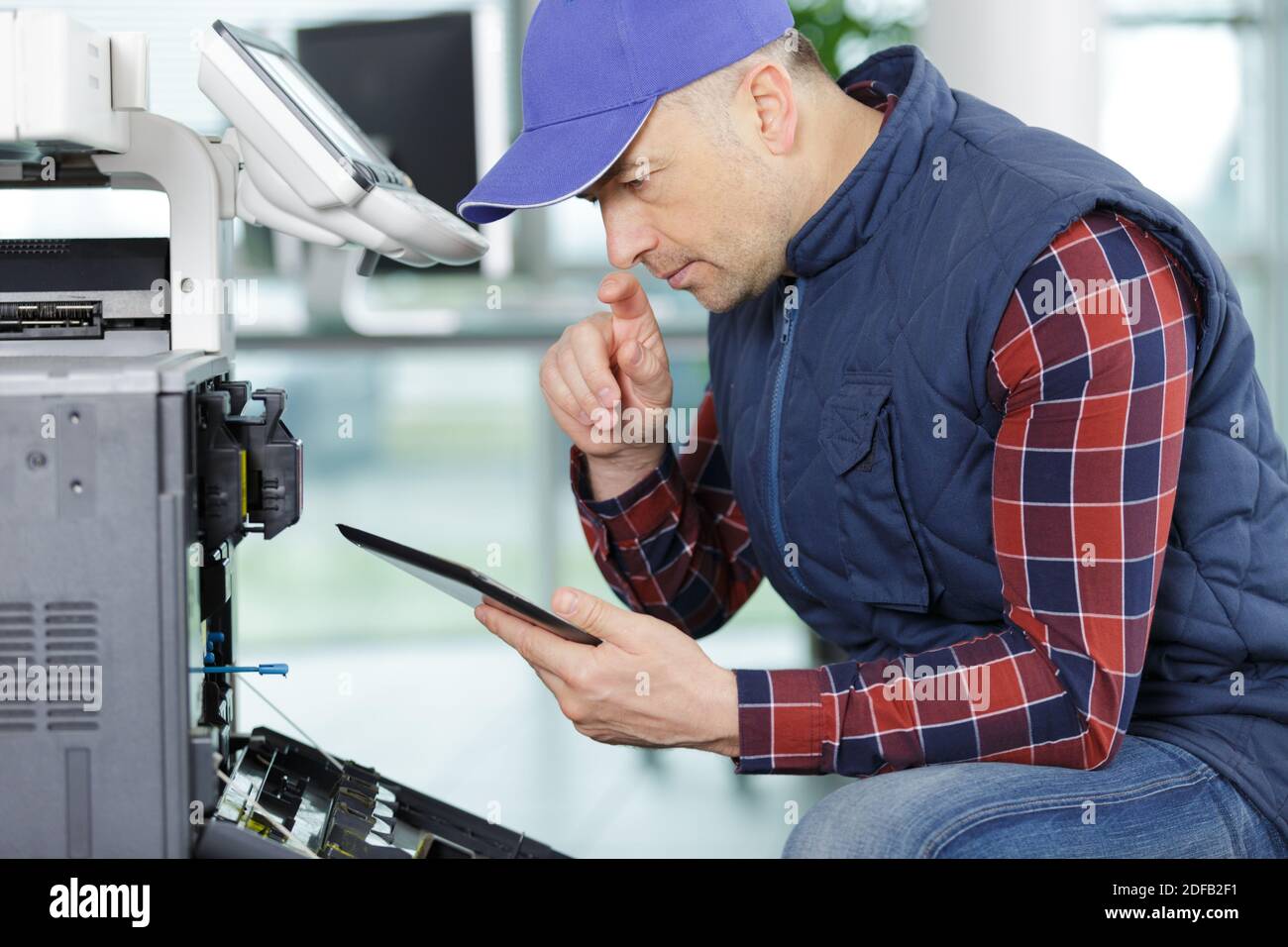 closeup shot young male technician repairing digital photocopier ...