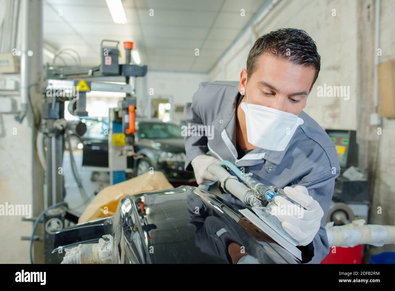 Mechanic polishing vehicle panel with machine Stock Photo - Alamy