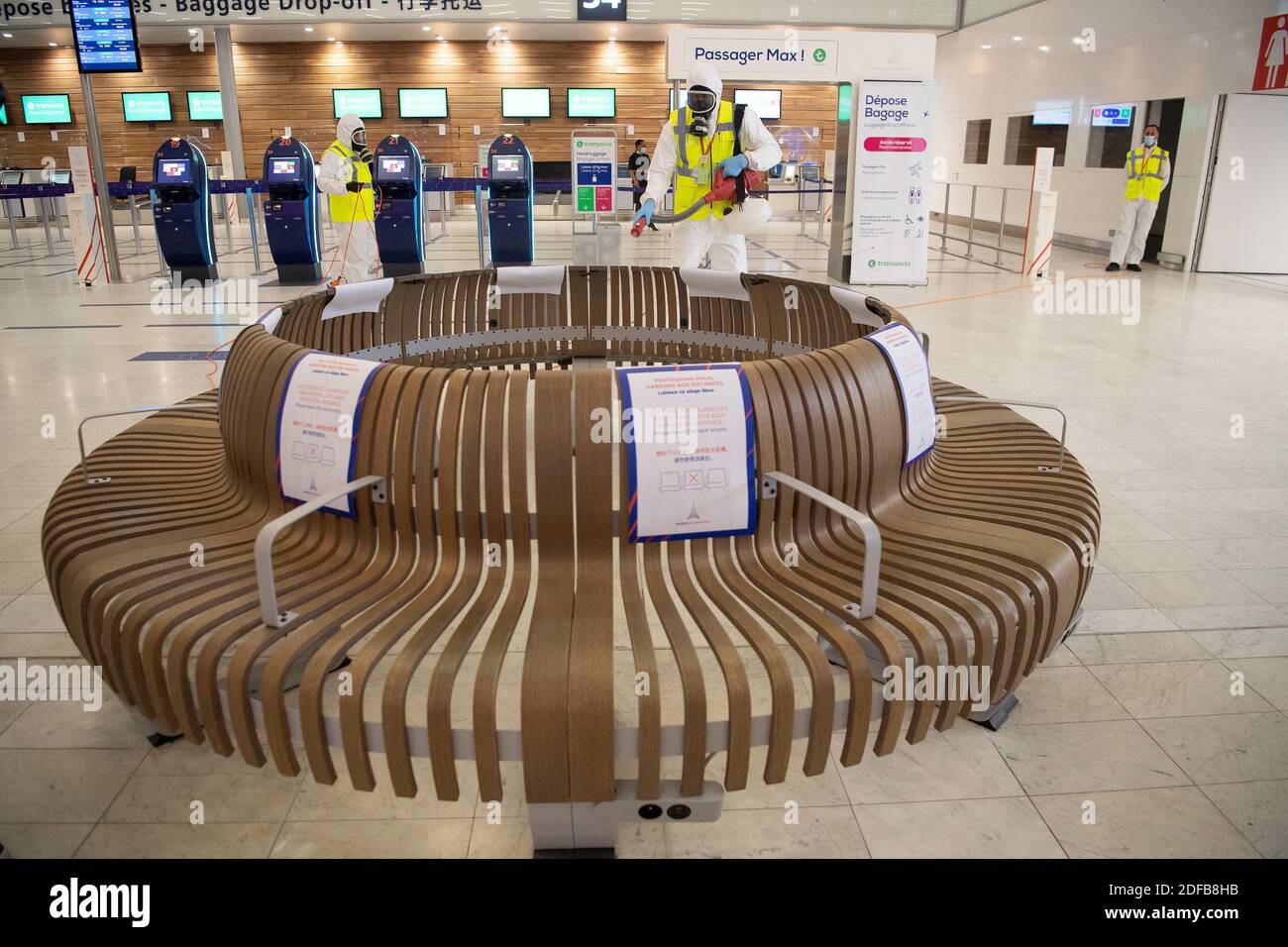 A worker in protective gear sprays disinfectant at Paris-Orly Airport ...
