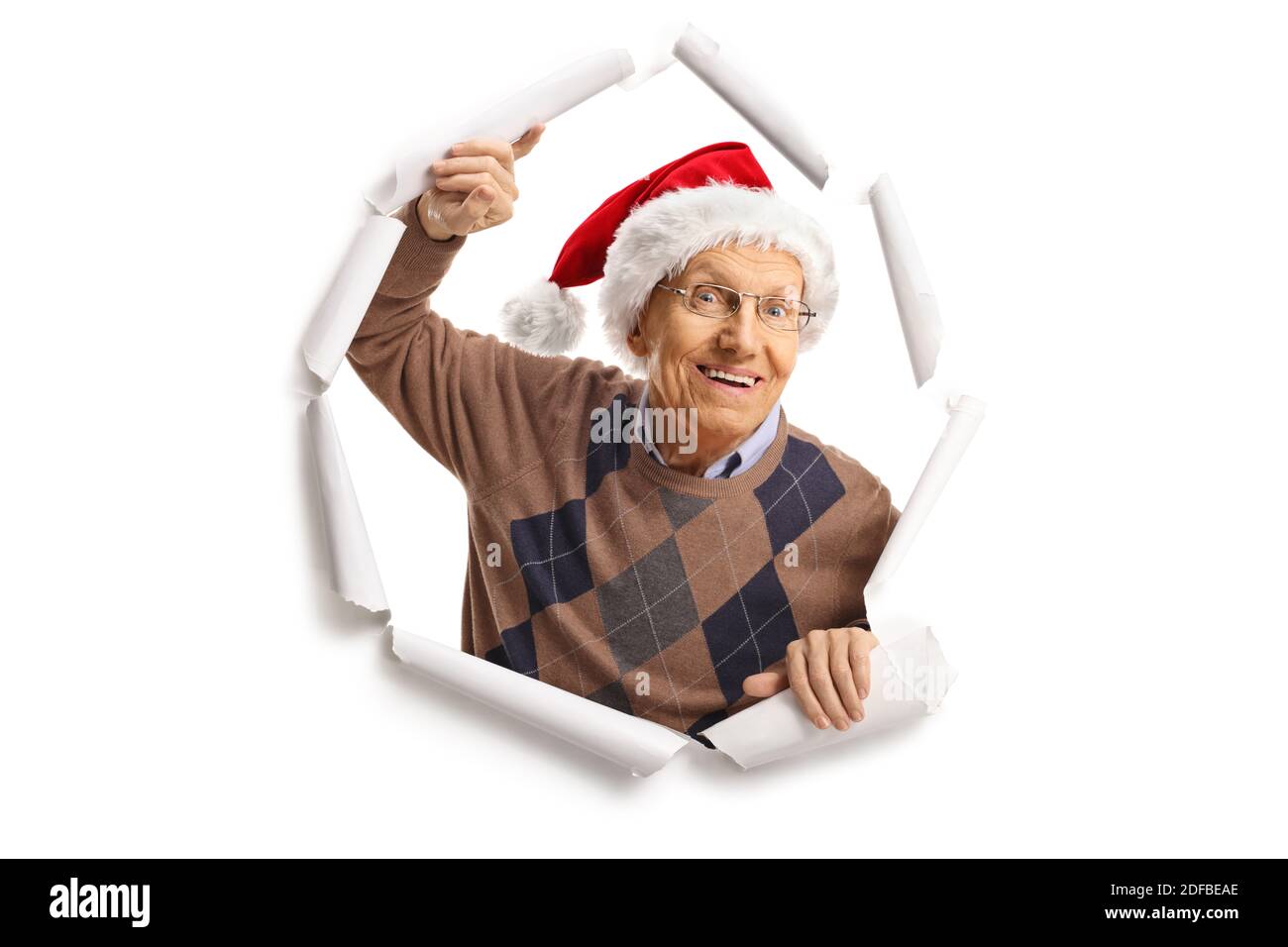 Cheerful elderly man breaking through paper and wearing a christmas ...