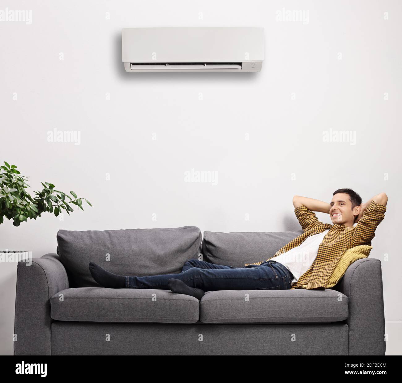 Man enjoying on a sofa with air conditioning unit on the wall isolated ...