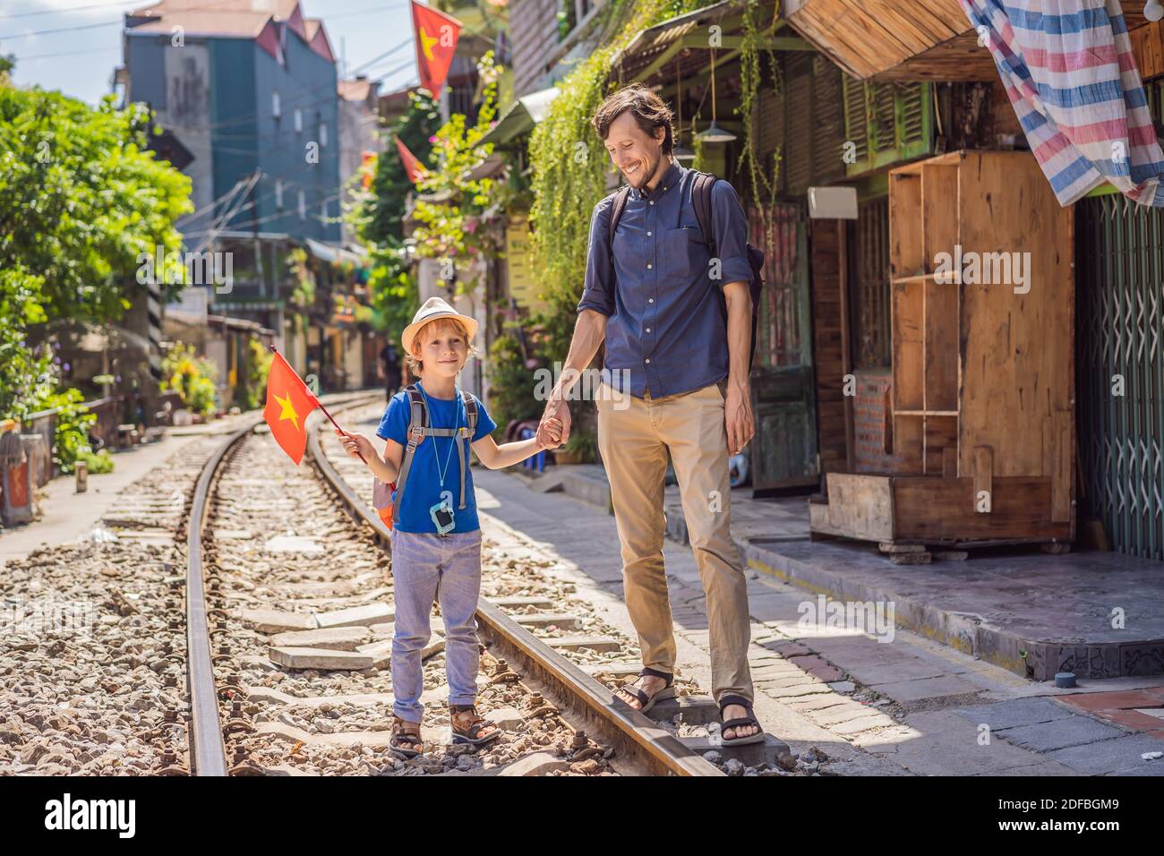 Father and son travelers walk around railway paths which go through ...