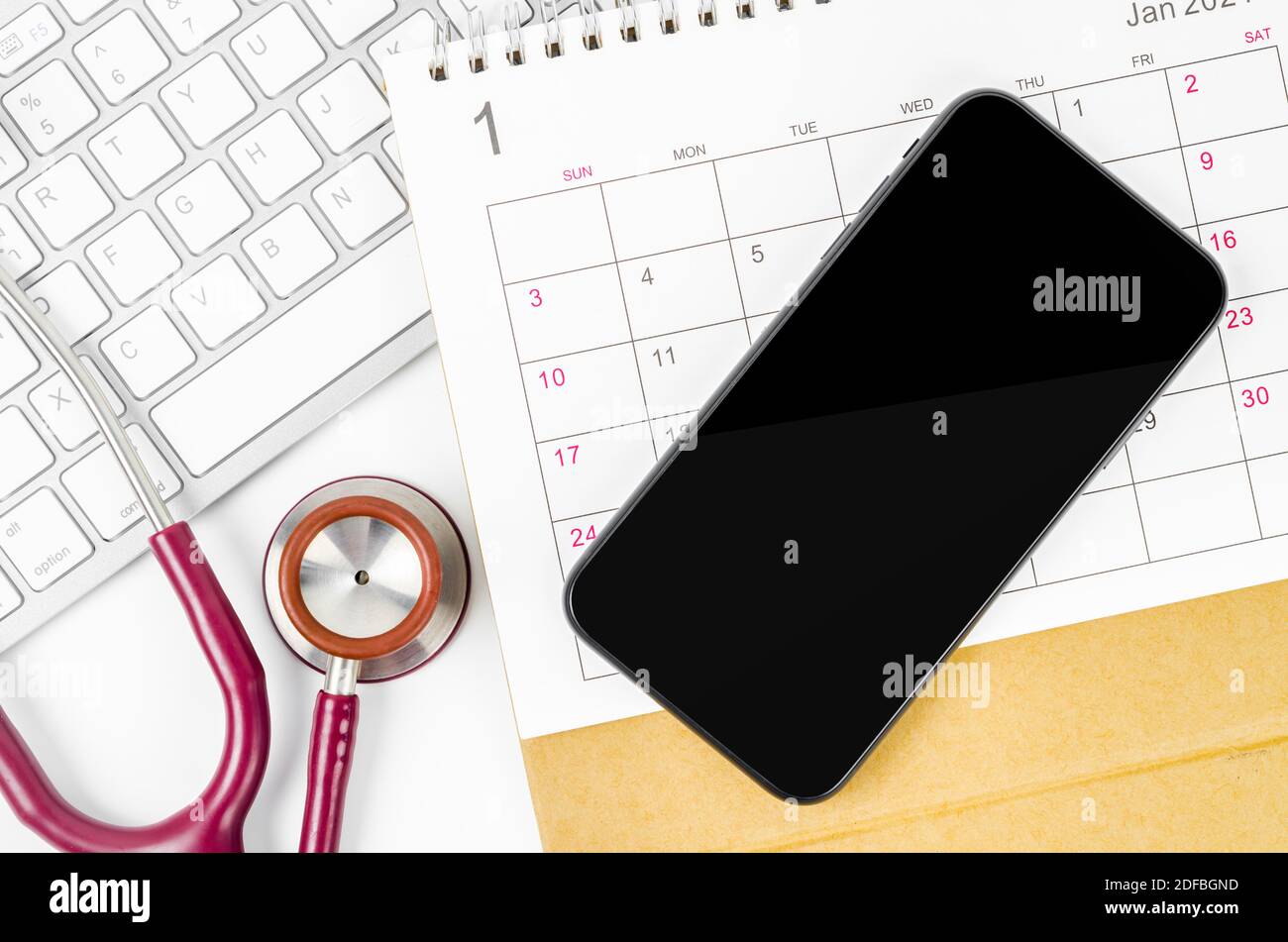 Mobile phone on calendar January and stethoscope with keyboard computer ...