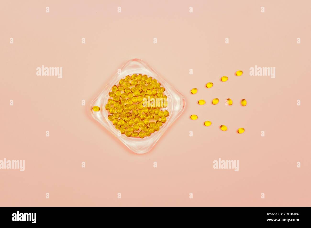 Small capsules of Omega 3 in the form of the fish lie on a rose ...