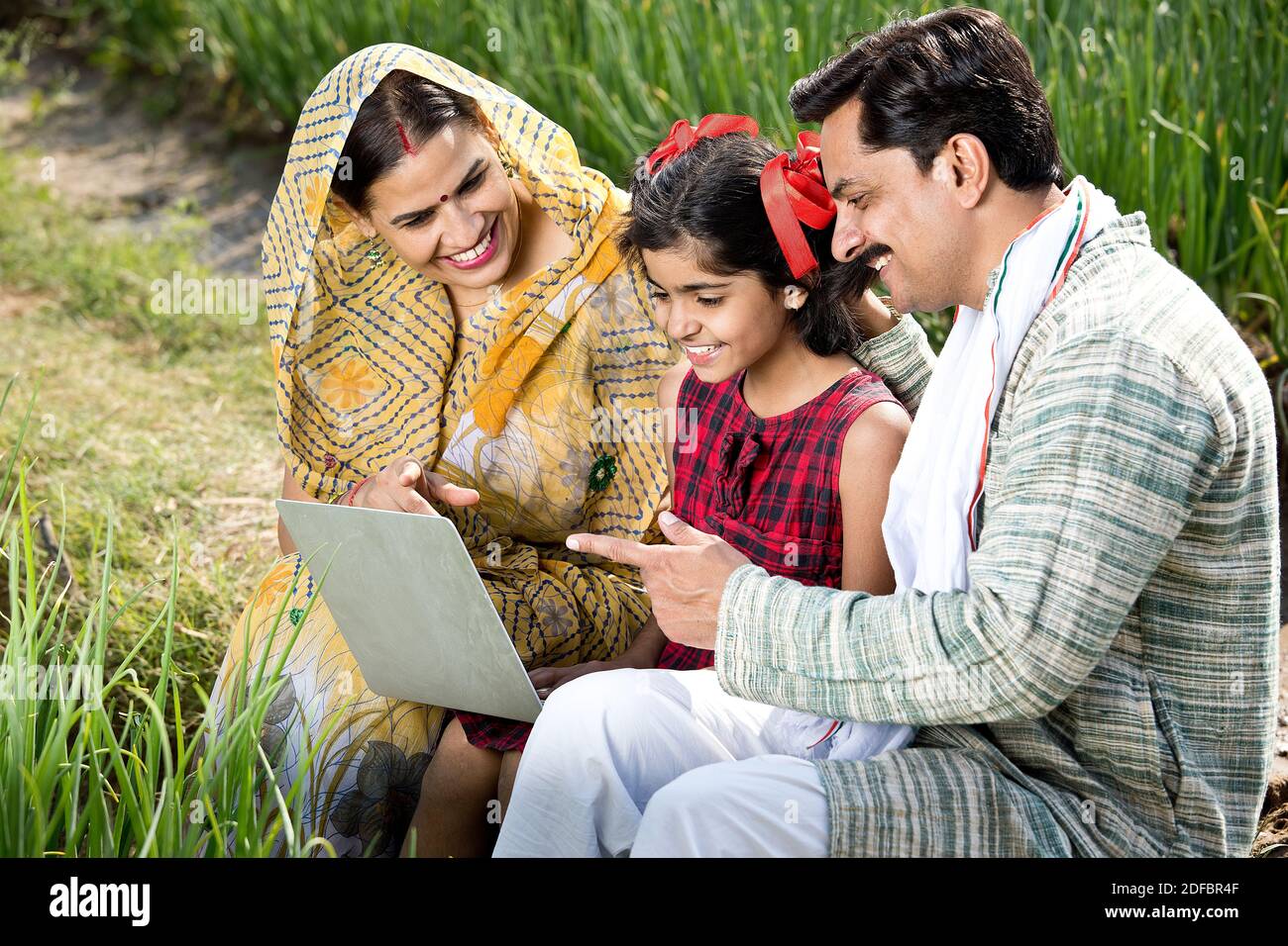 Rural family using laptop on agriculture field Stock Photo - Alamy