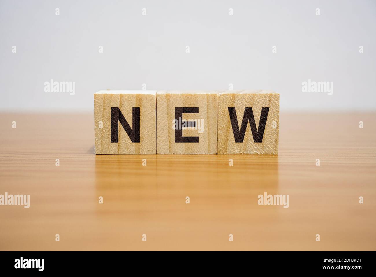 Wooden block on desk with the word New word Stock Photo - Alamy