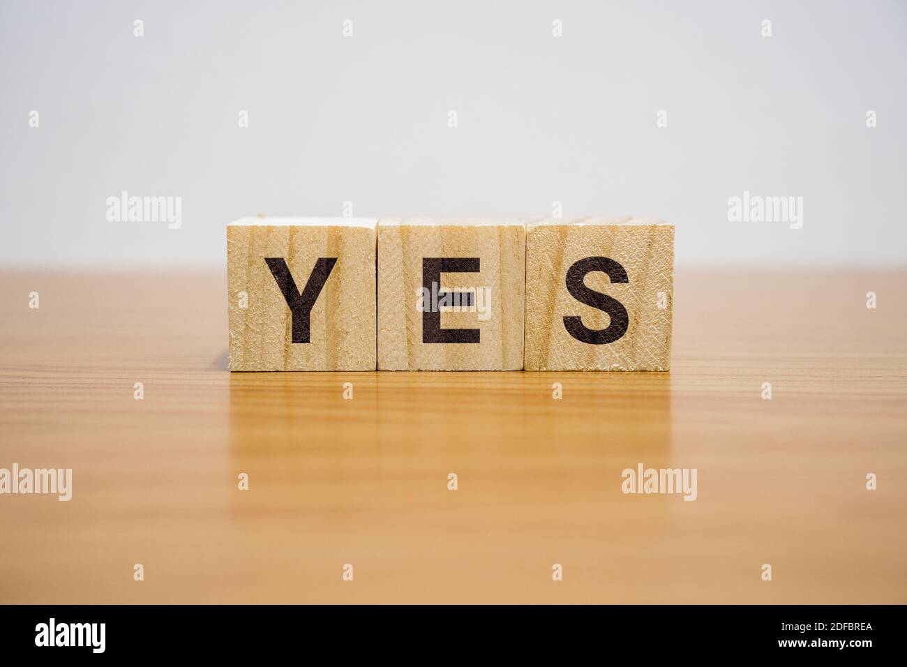 Wooden block on desk with the word Yes Stock Photo - Alamy