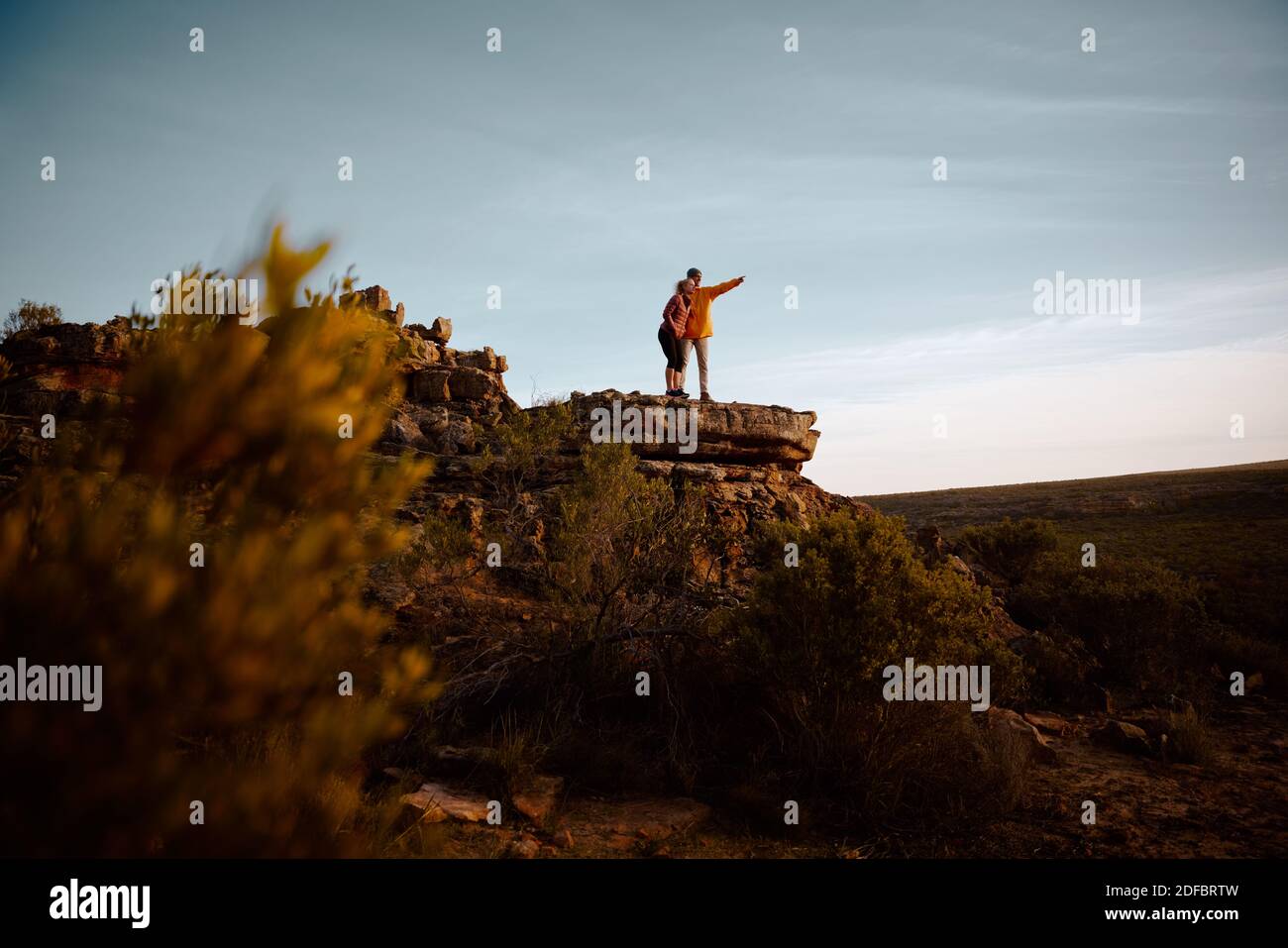 Low angle view of young man pointing at something with woman standing ...