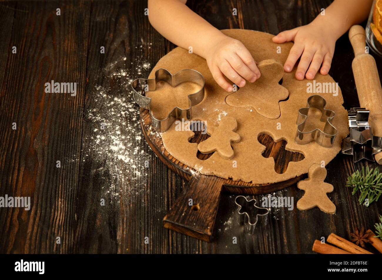 Little child hands making gingerbread men and festive decorations Stock ...
